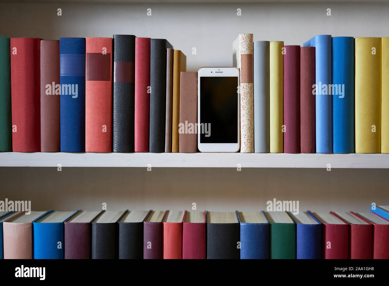 Mobile phone in bookshelf with sorted books Stock Photo - Alamy