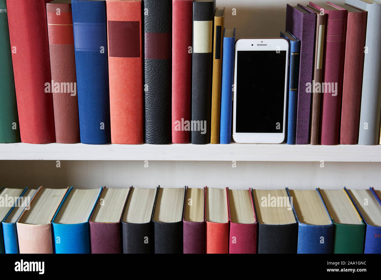 Accurate bookcase with front view of a new mobile phone Stock Photo - Alamy