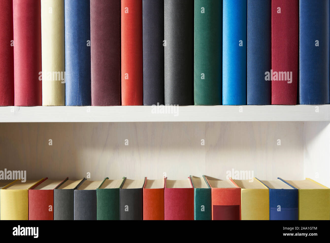 Close up of rows of books with colorful covers in a white shelf Stock ...