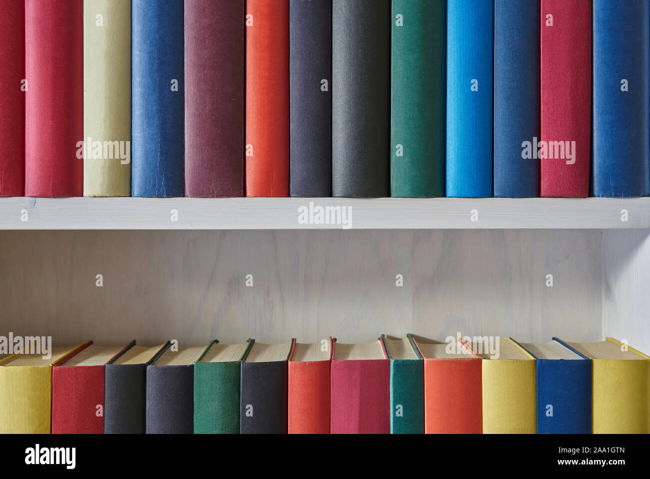 Close up of rows of books with colorful covers in a white shelf Stock ...