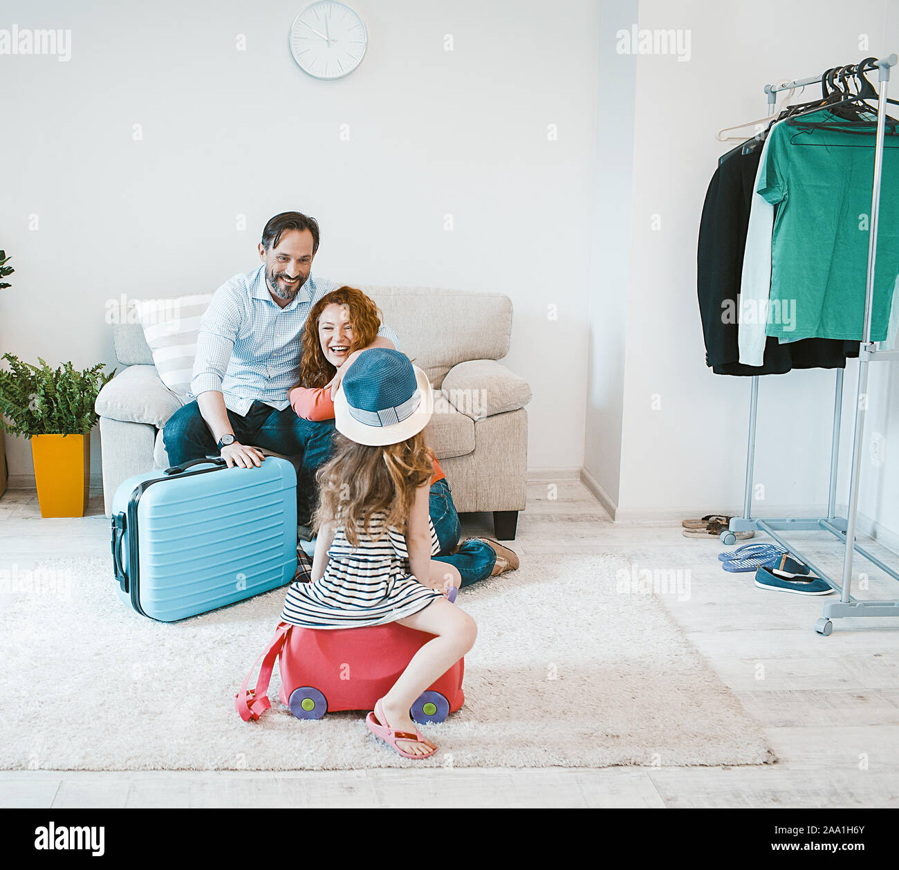 Happy parents and little girl going on vacation Stock Photo - Alamy