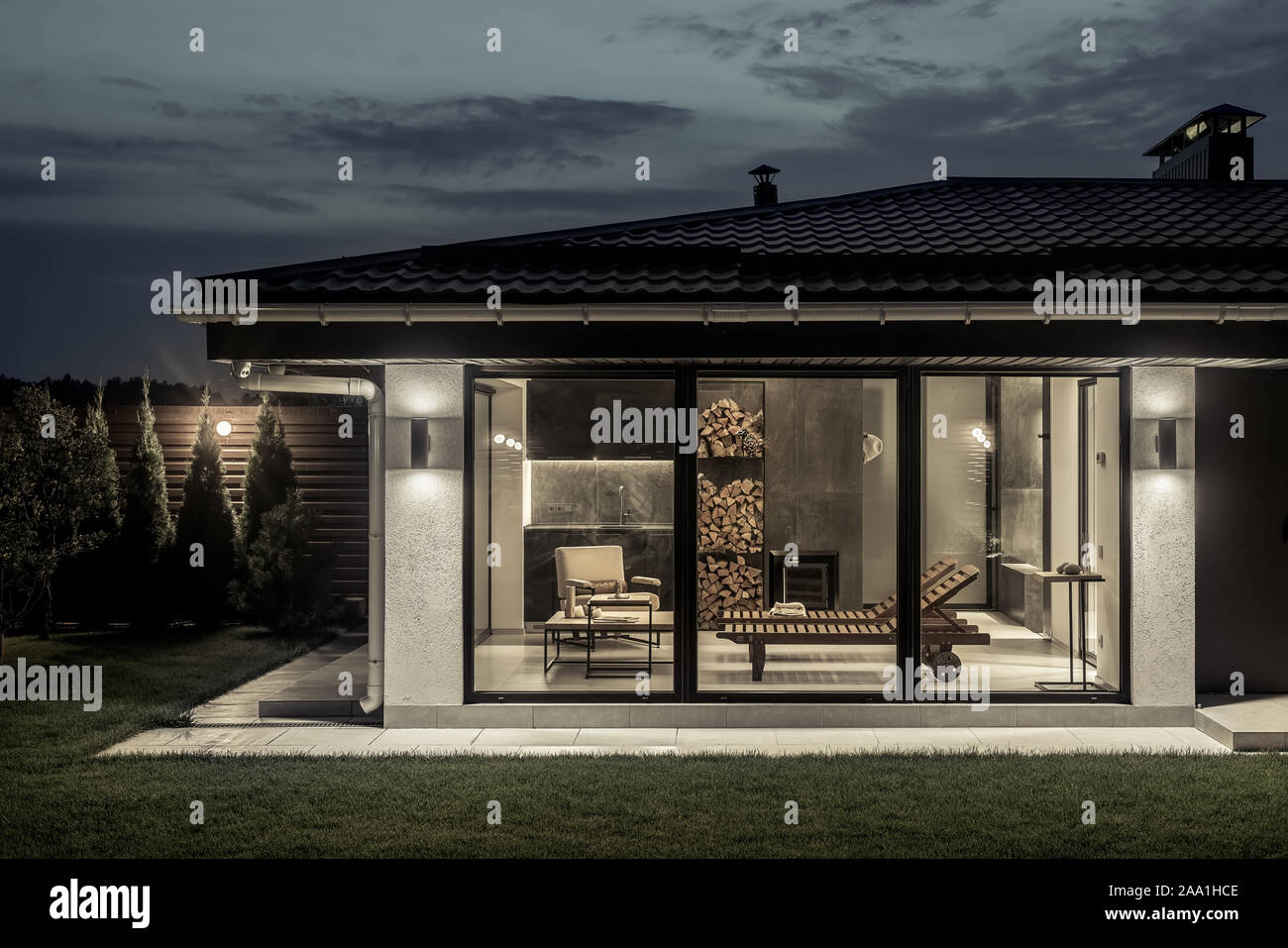 Luminous modern spa building with a glass wall with doors on the dark ...