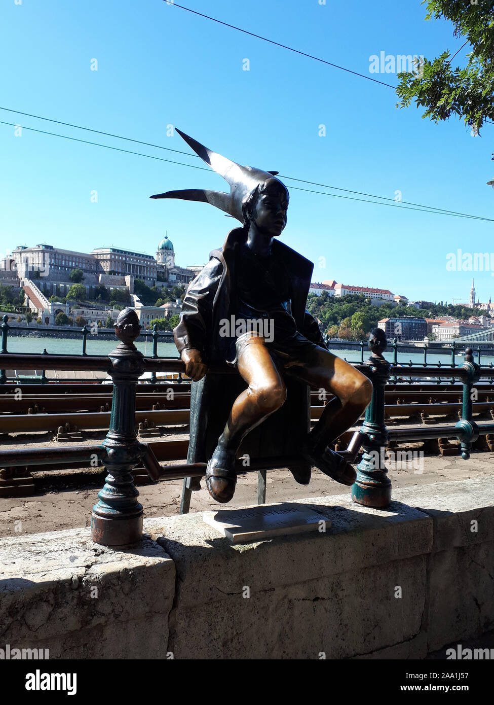 The statue of the Little Princess statue sitting on the railings of the Danube promenade in ...