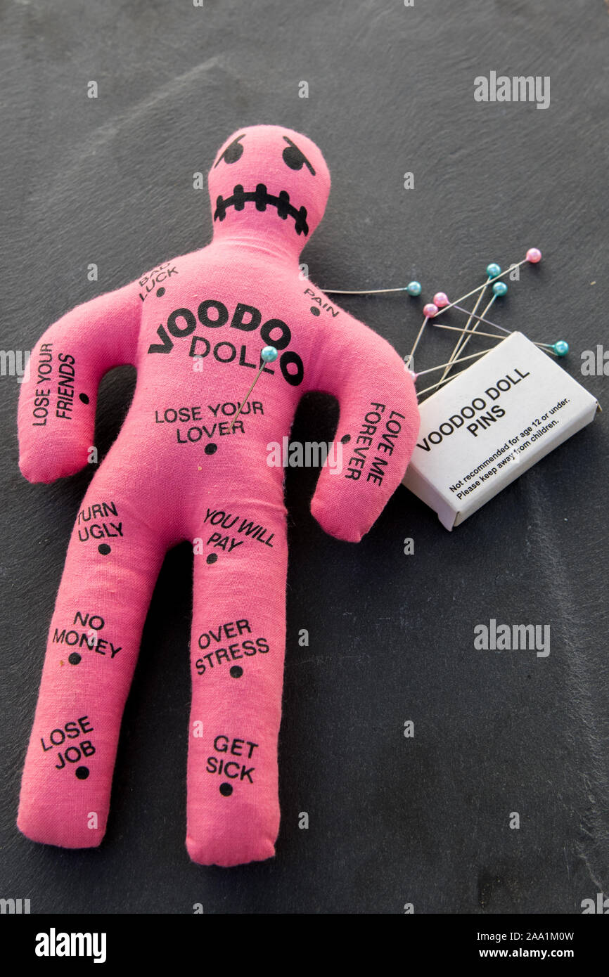 Pink Voodoo doll with a books of voodoo pins or needles Stock Photo - Alamy