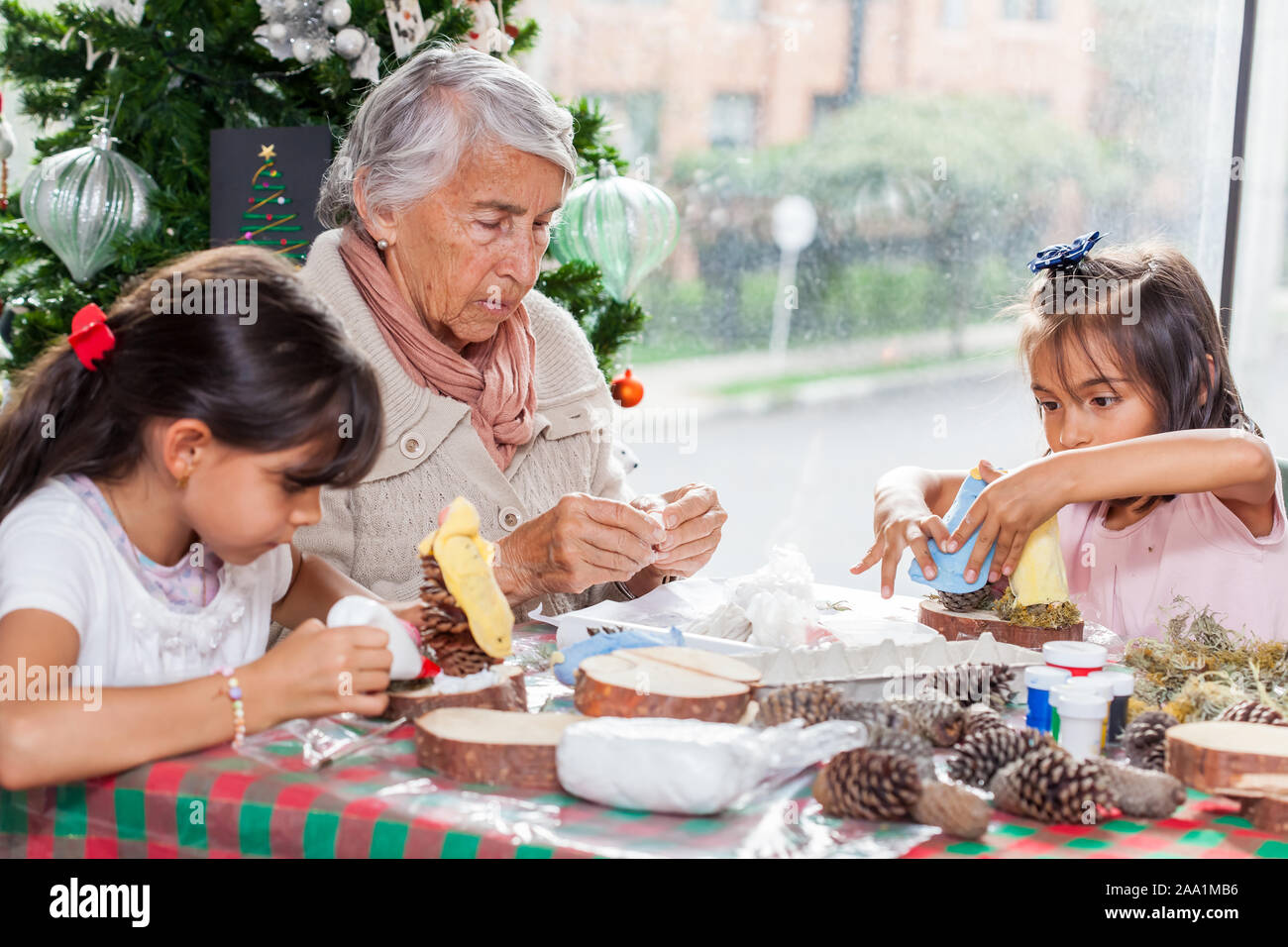 Grandmother teaching her granddaughters how to make christmas Nativity ...