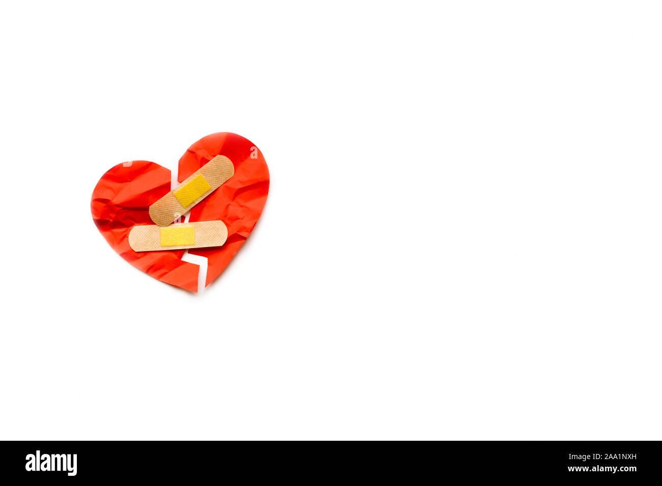 Broken red heart symbol with medical patch on white background, love ...