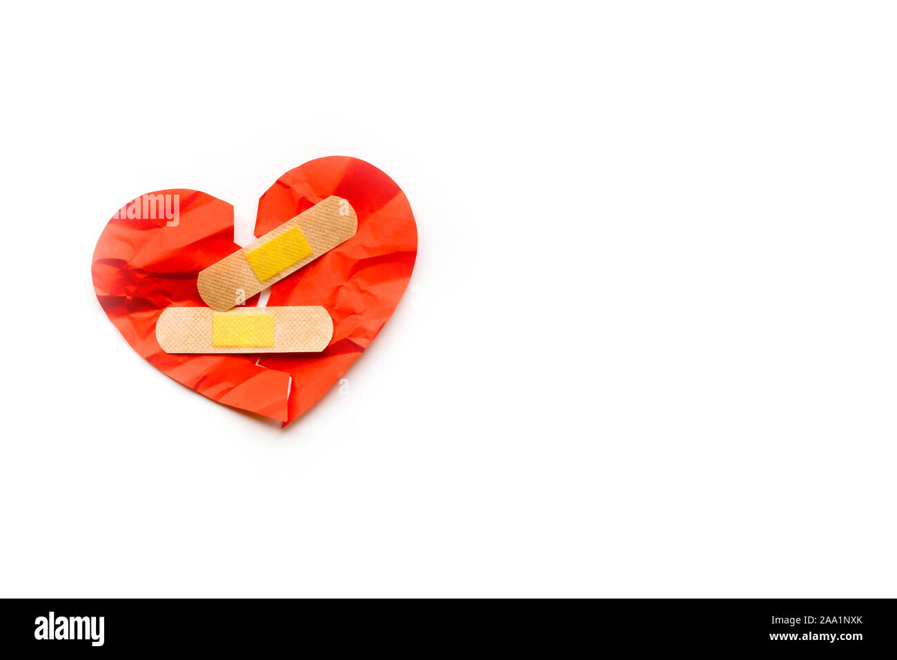 Broken red heart symbol with medical patch on white background, love ...