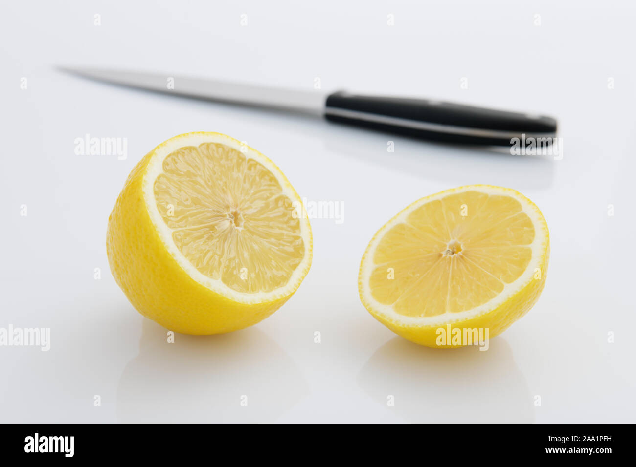 Close up, detail, fresh sliced lemon fruit, knife, high key background ...