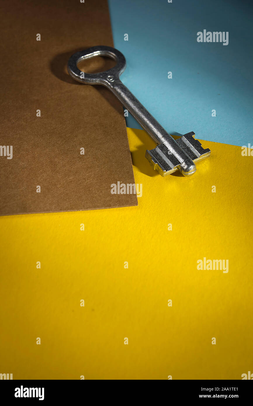 Metal old key on a brown cardboard tablet Stock Photo - Alamy