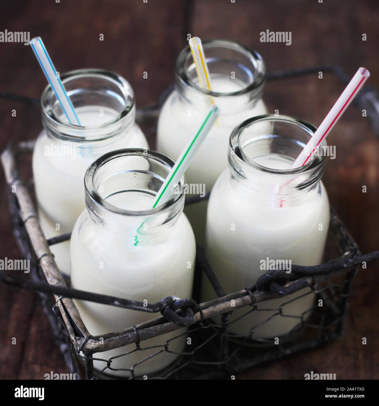 Four Small Bottles Of Milk With Straws Stock Photo - Alamy