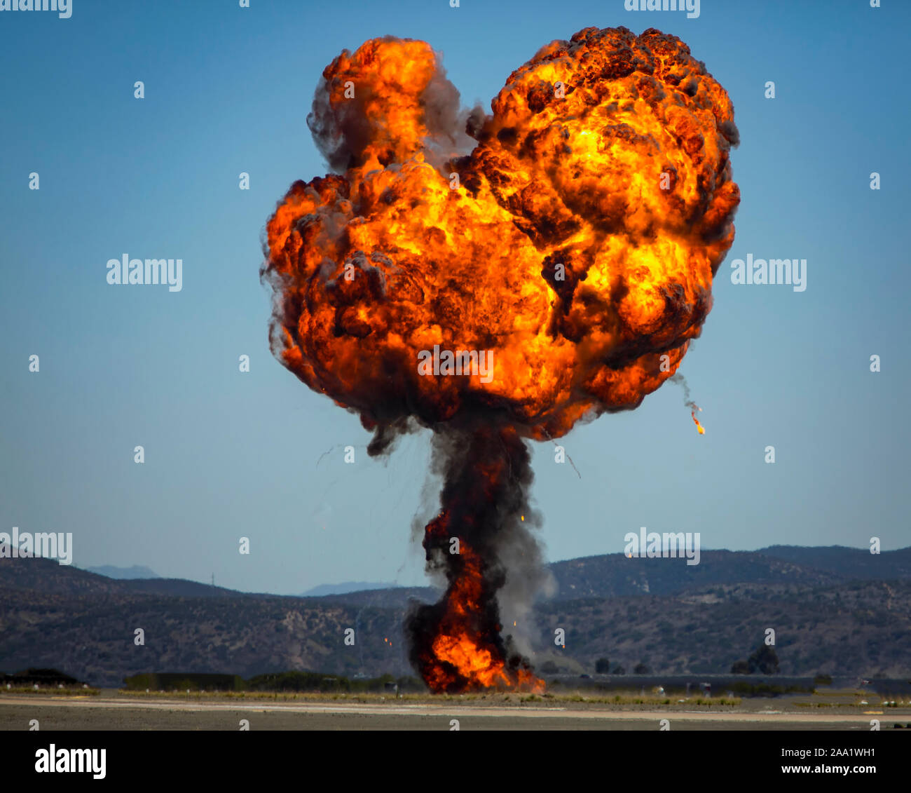 Heart shapped ball of fire and column of smoke from munitions explosion ...