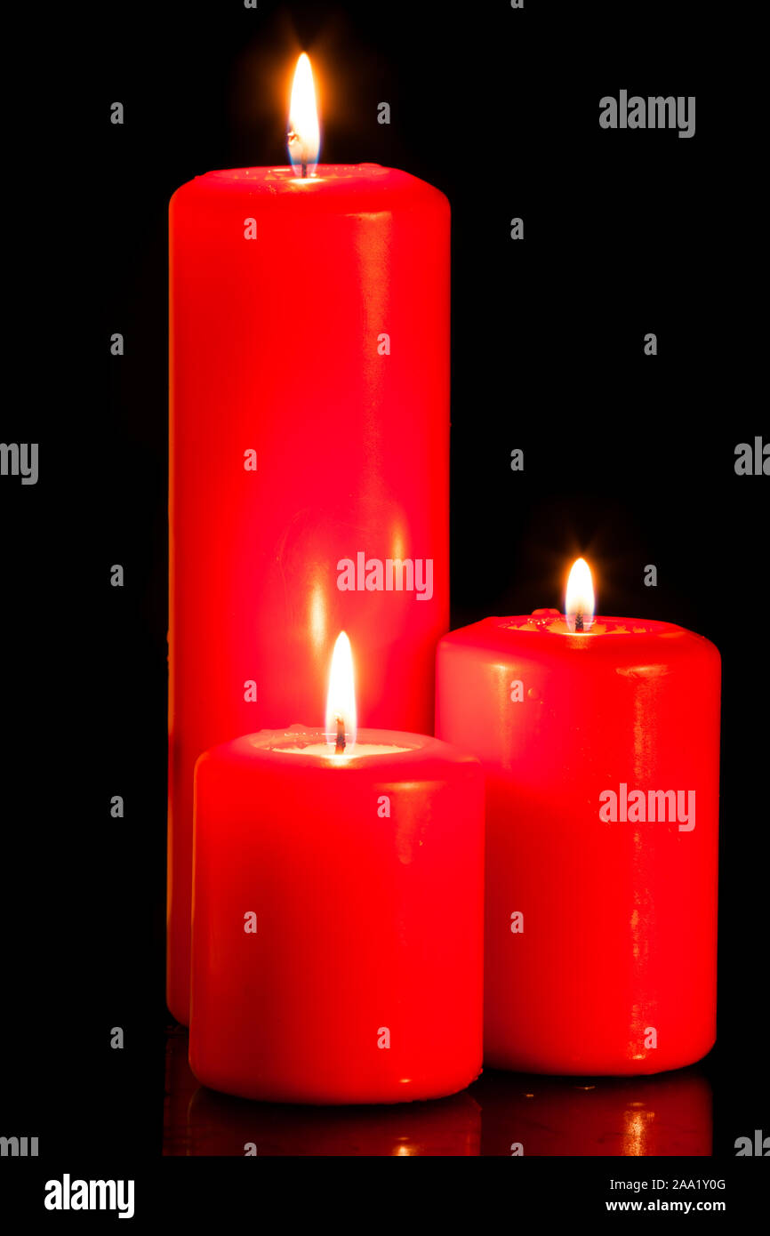 Three red candles on black background Stock Photo - Alamy