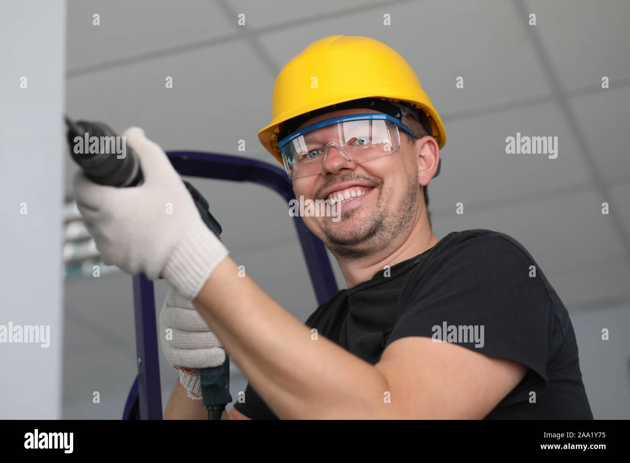 Worker drilling wall in room Stock Photo - Alamy
