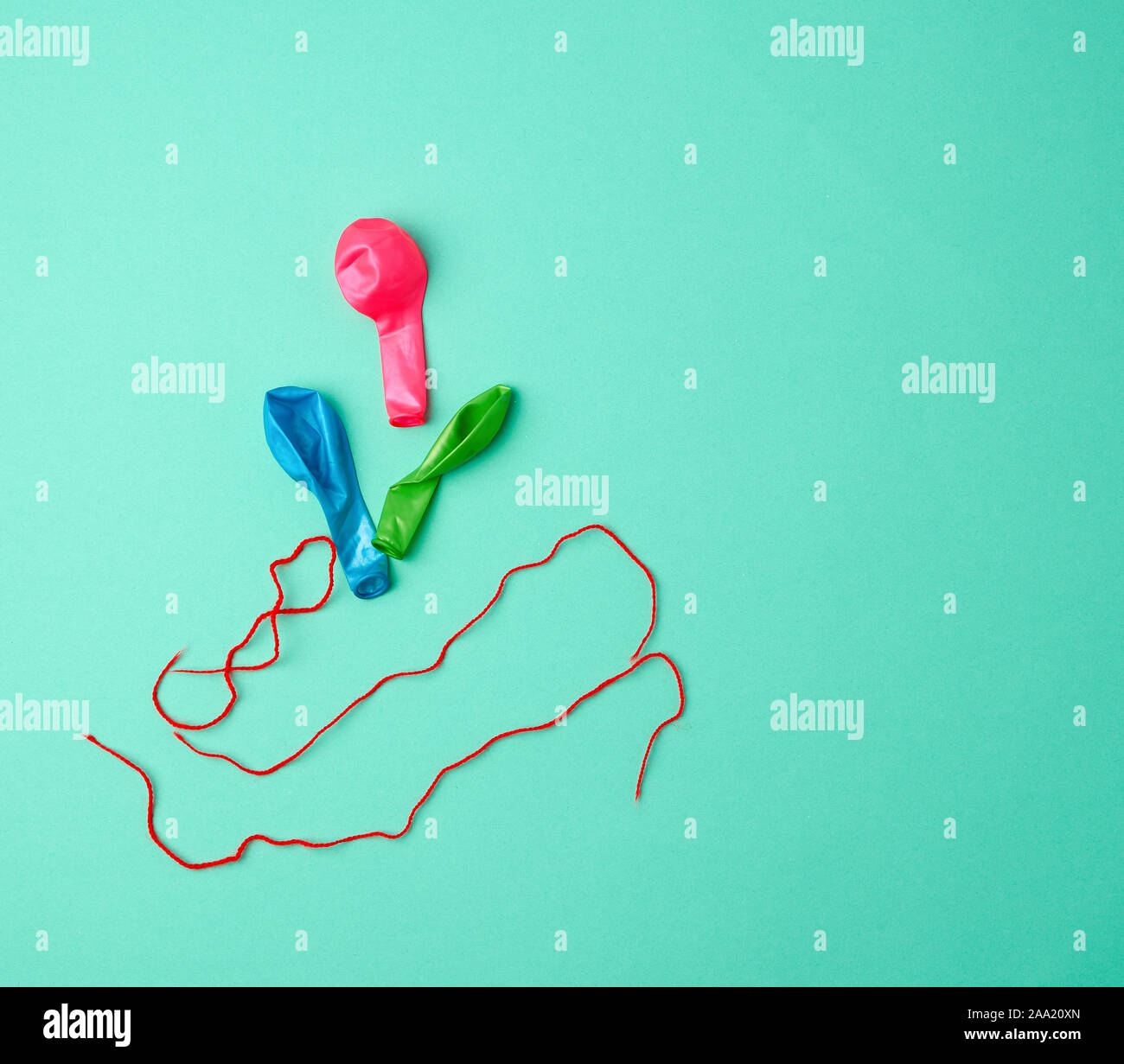 deflated rubber balls and red rope on a green background, copy space ...