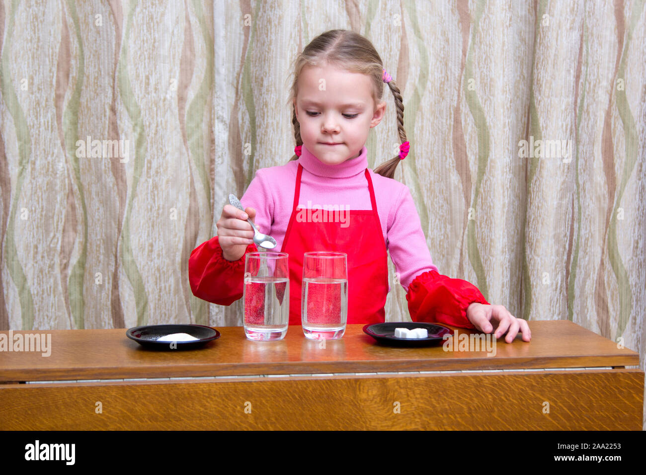 pretty little girl doing physical experiments with water at home Stock ...