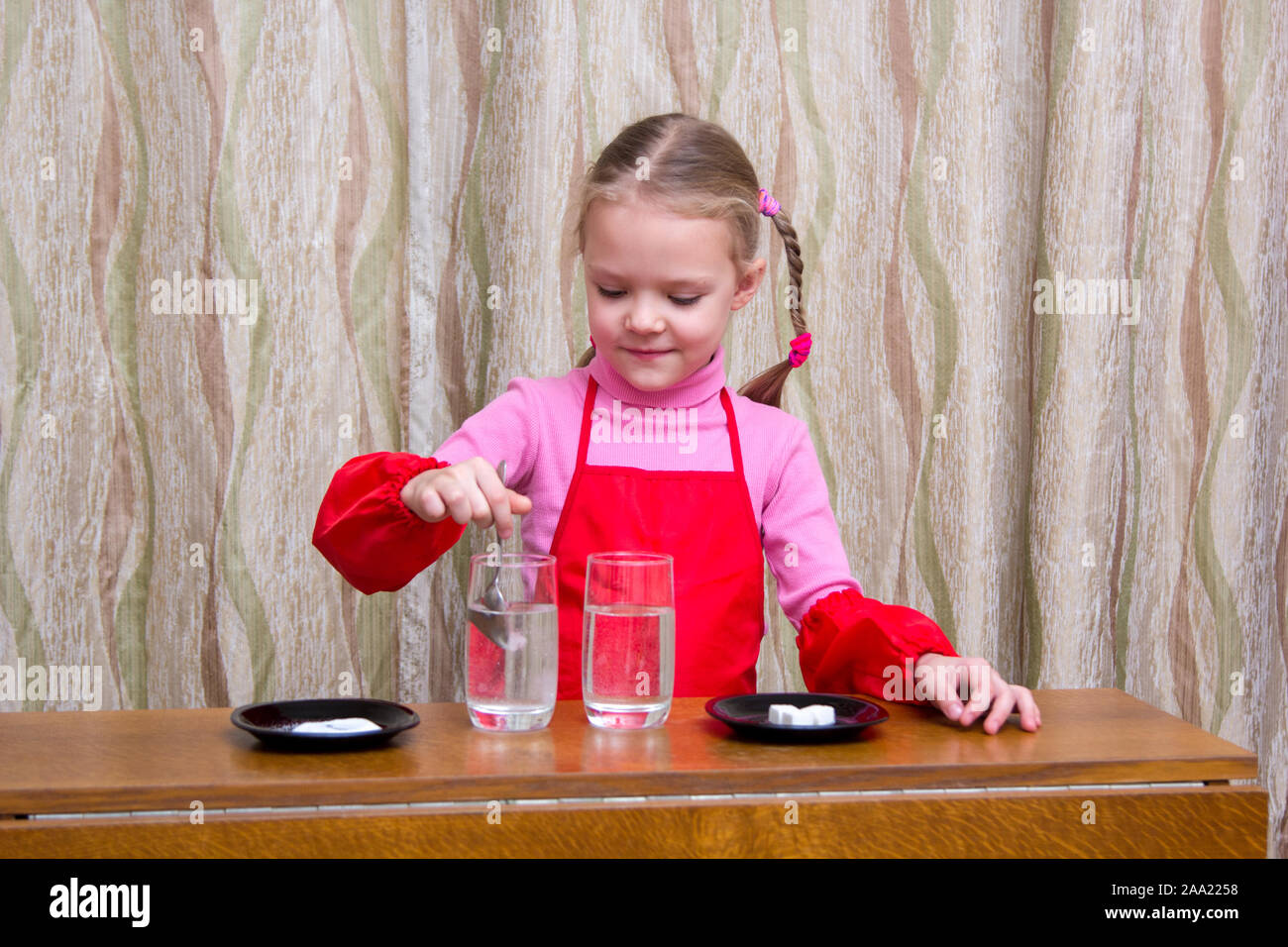 pretty little girl doing physical experiments with water at home Stock ...