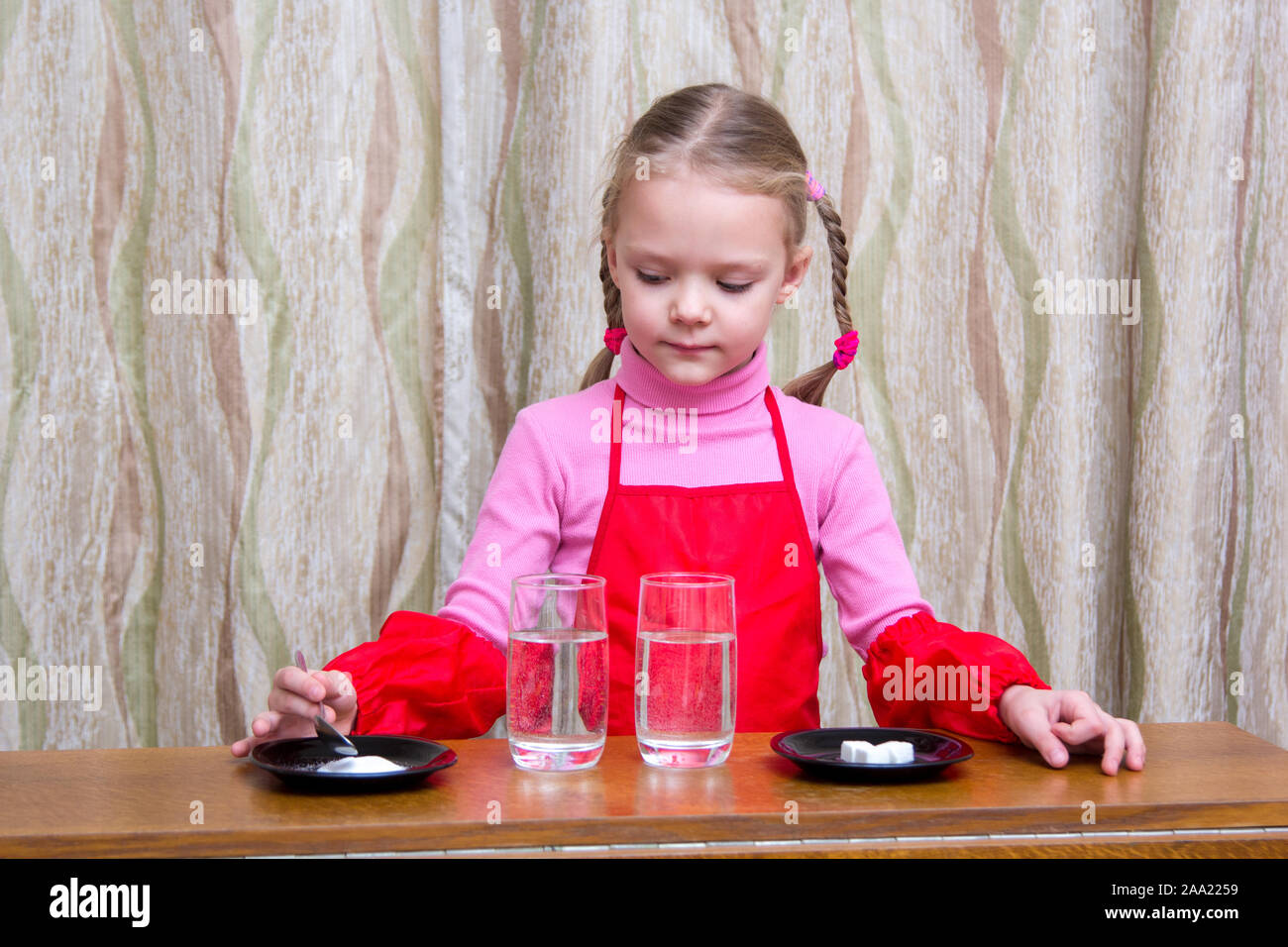 pretty little girl doing physical experiments with water at home Stock ...