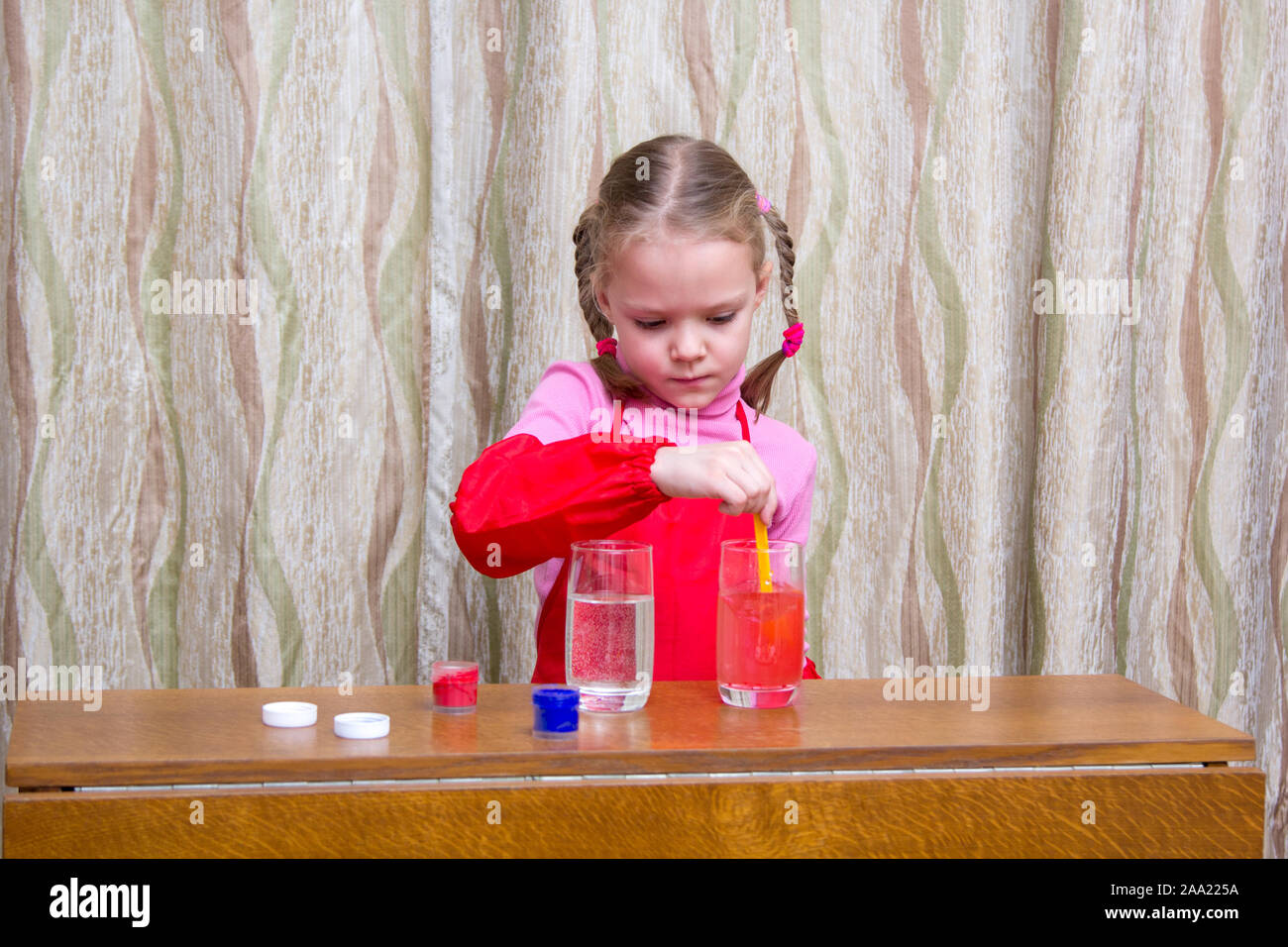 pretty little girl doing physical experiments with water at home Stock ...