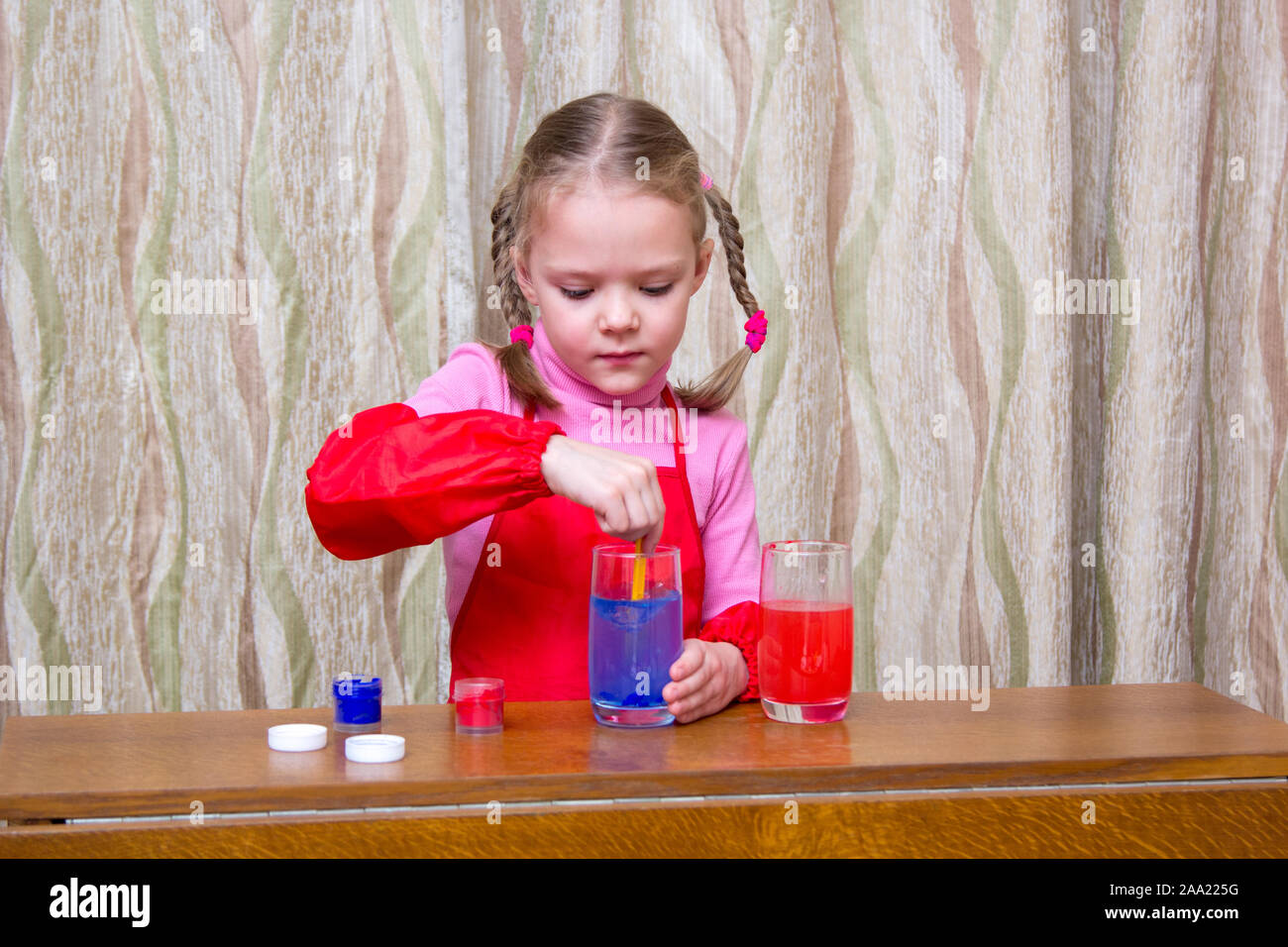 pretty little girl doing physical experiments with water at home Stock ...