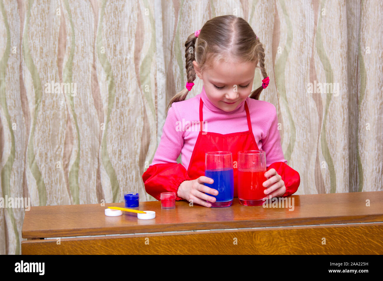 pretty little girl doing physical experiments with water at home Stock ...