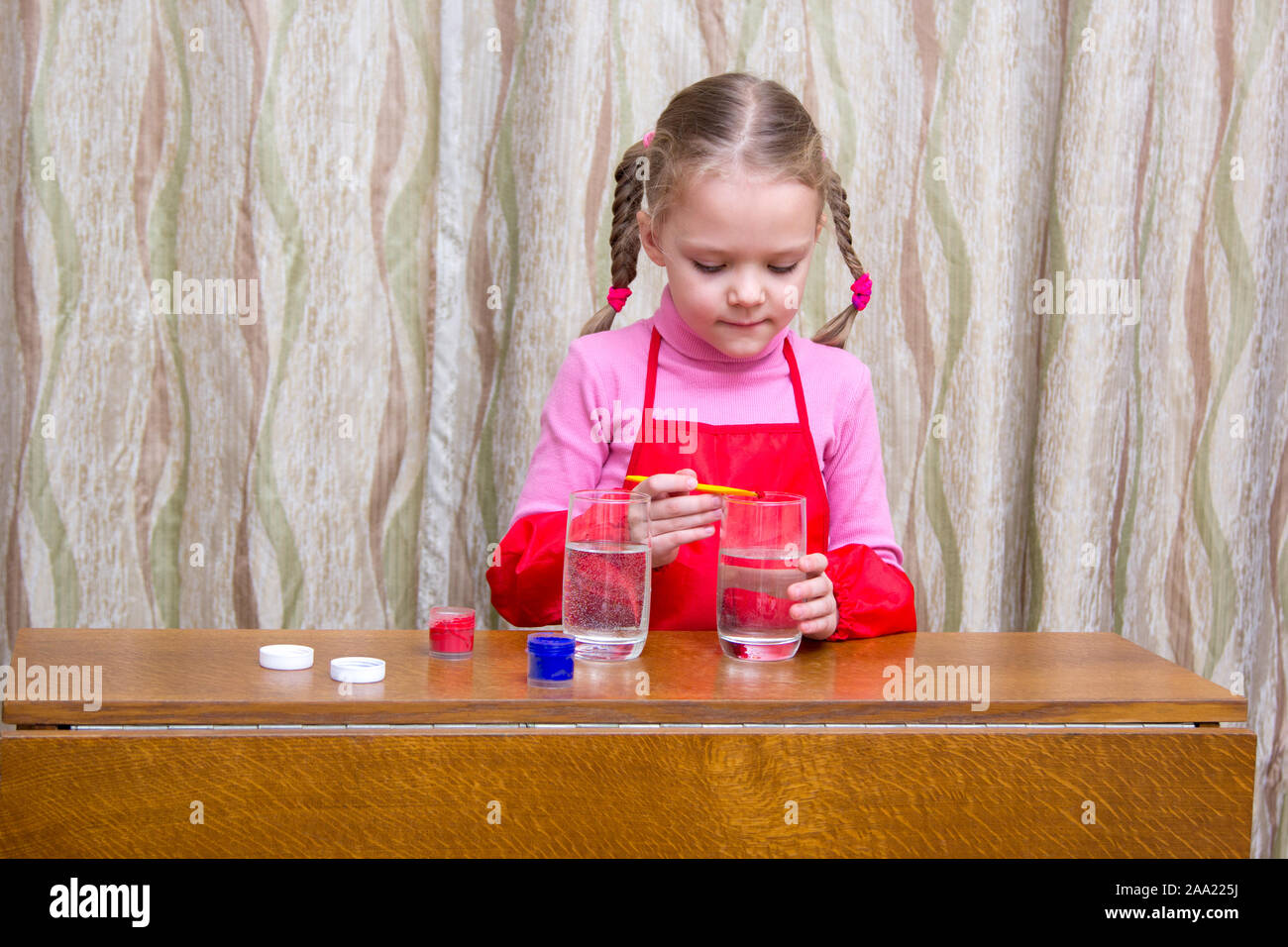 pretty little girl doing physical experiments with water at home Stock ...