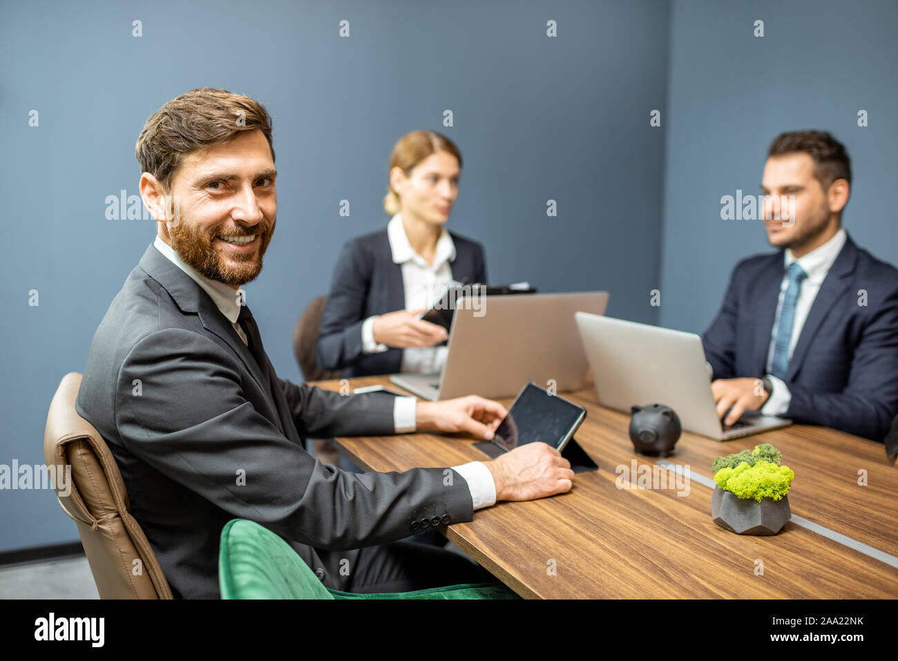 Portrait of a handsome smiling business man sitting during a conference ...