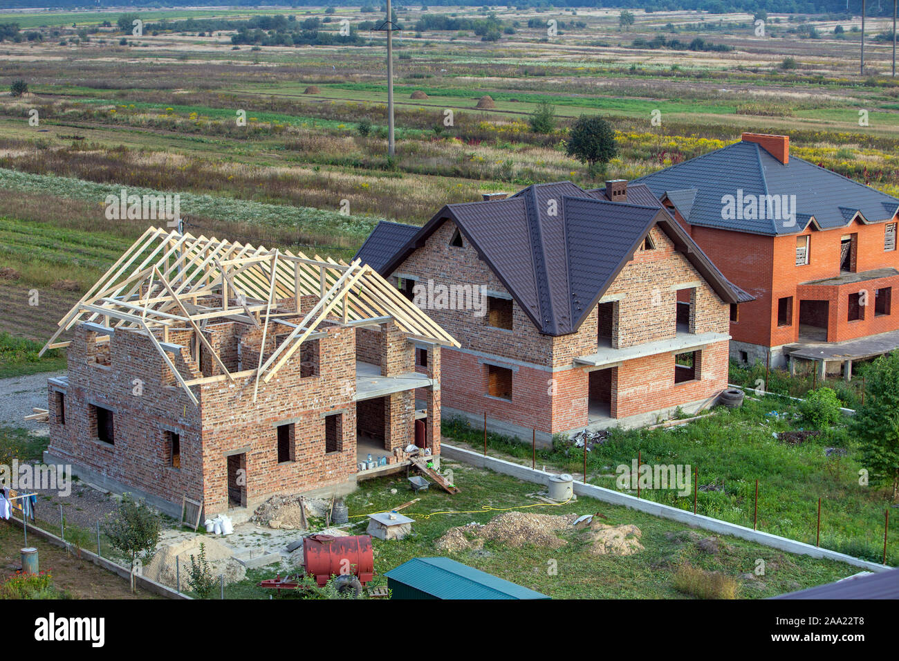 Unfinished brick house with wooden roof structure under construction ...