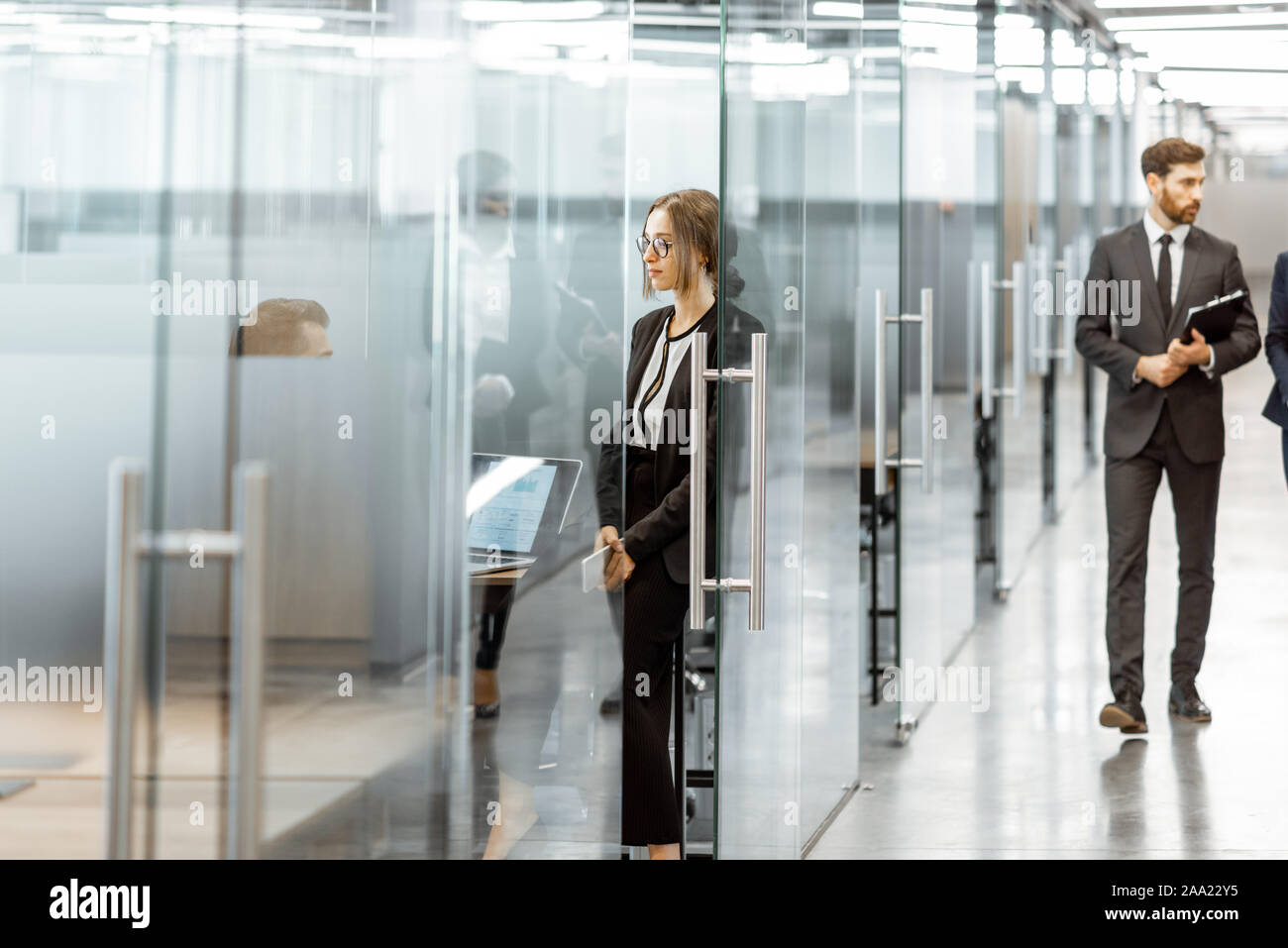 Business people walking in the hallway of the modern office building ...