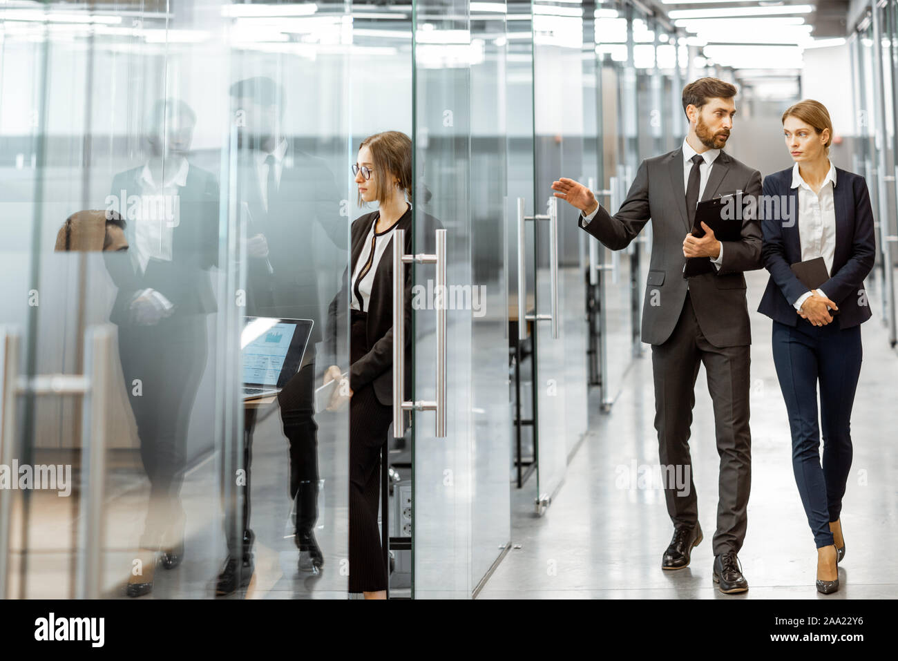 Business people walking in the hallway of the modern office building ...