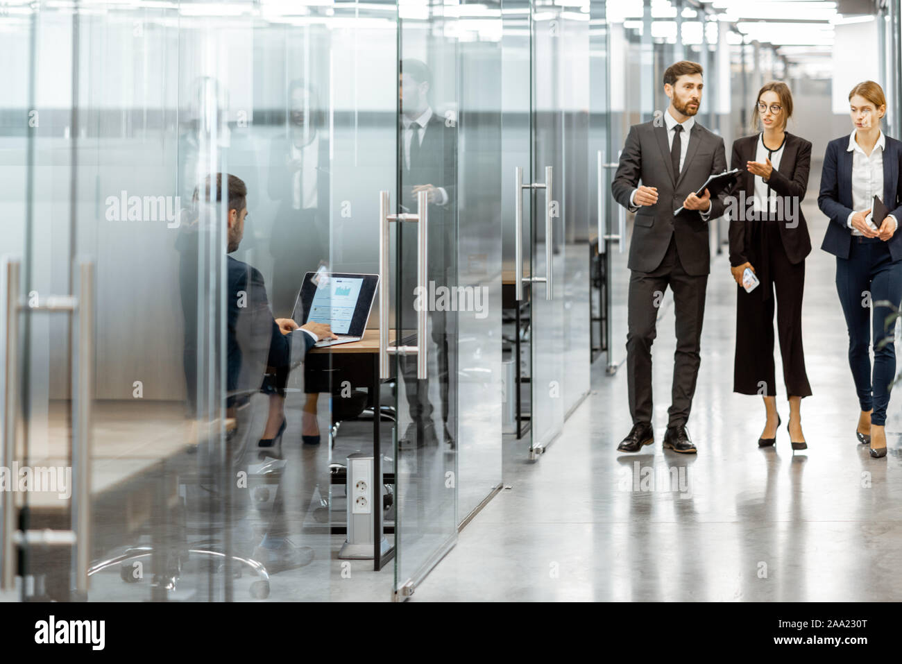 Business people walking in the hallway of the modern office building ...