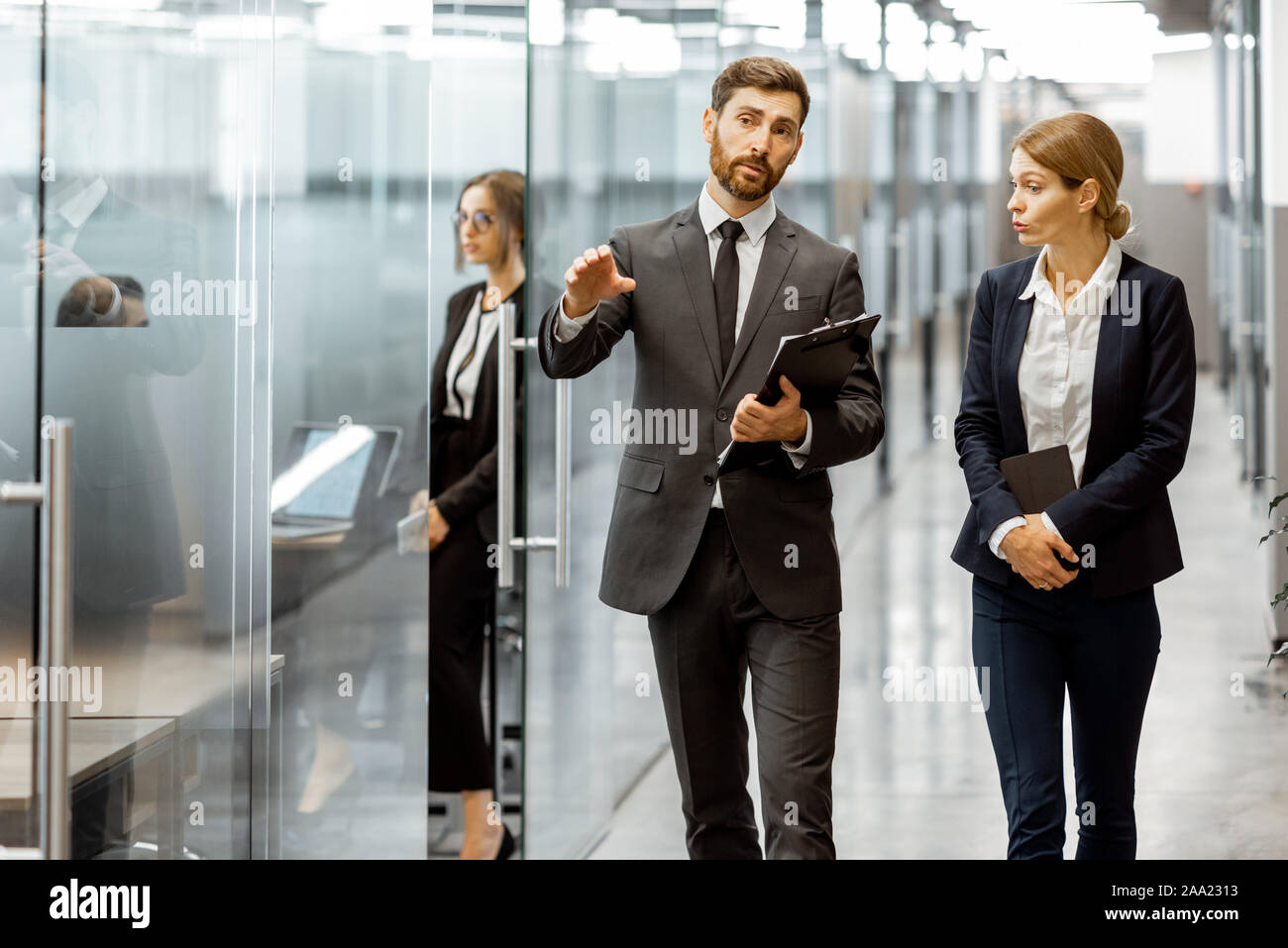 Business people walking in the hallway of the modern office building ...