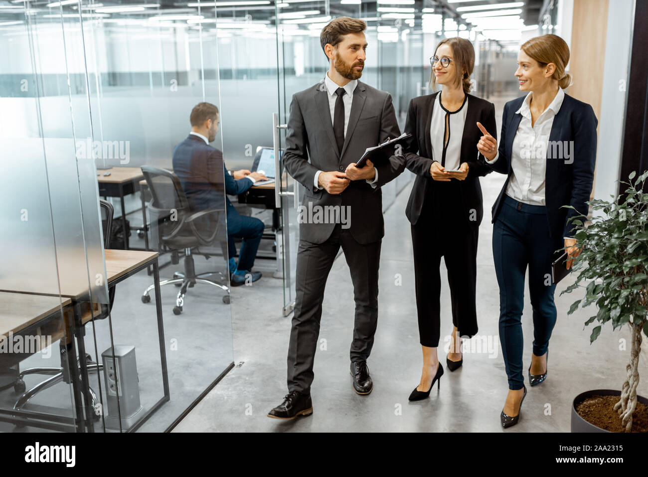 Business people walking in the hallway of the modern office building ...