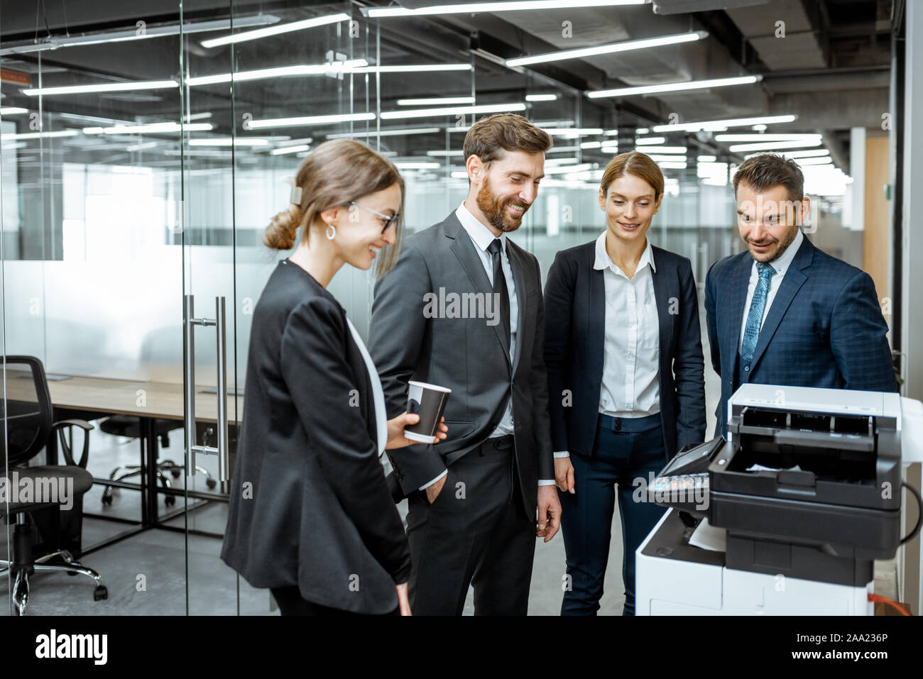 Group of business people hanging out together near the copier during a ...