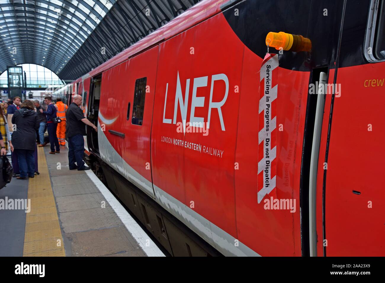 LNER railway staff servicing a Class 90 electric train at Kings Cross Station, London, with a ...