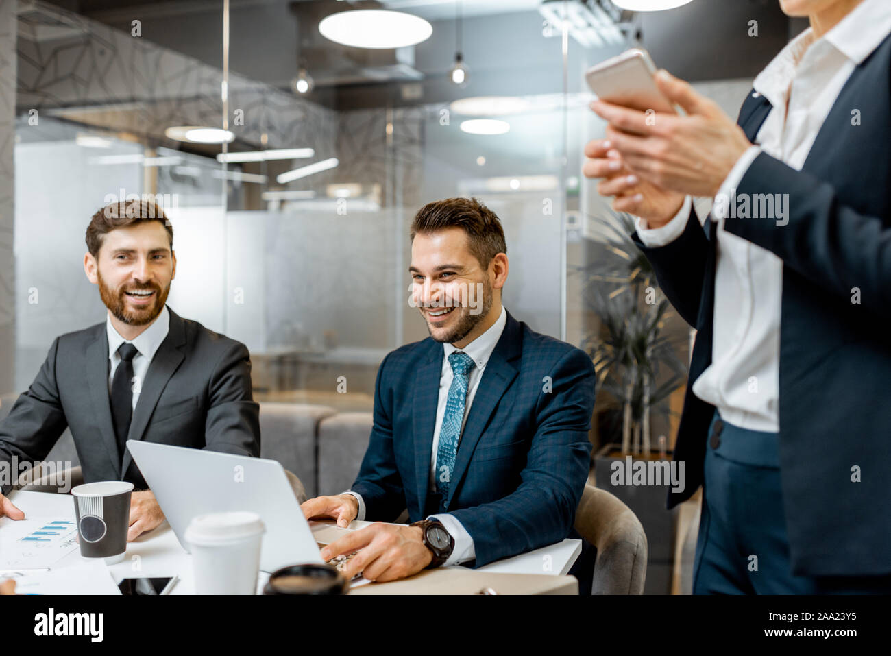 Business men stricly dressed in the suits sitting during a conference ...