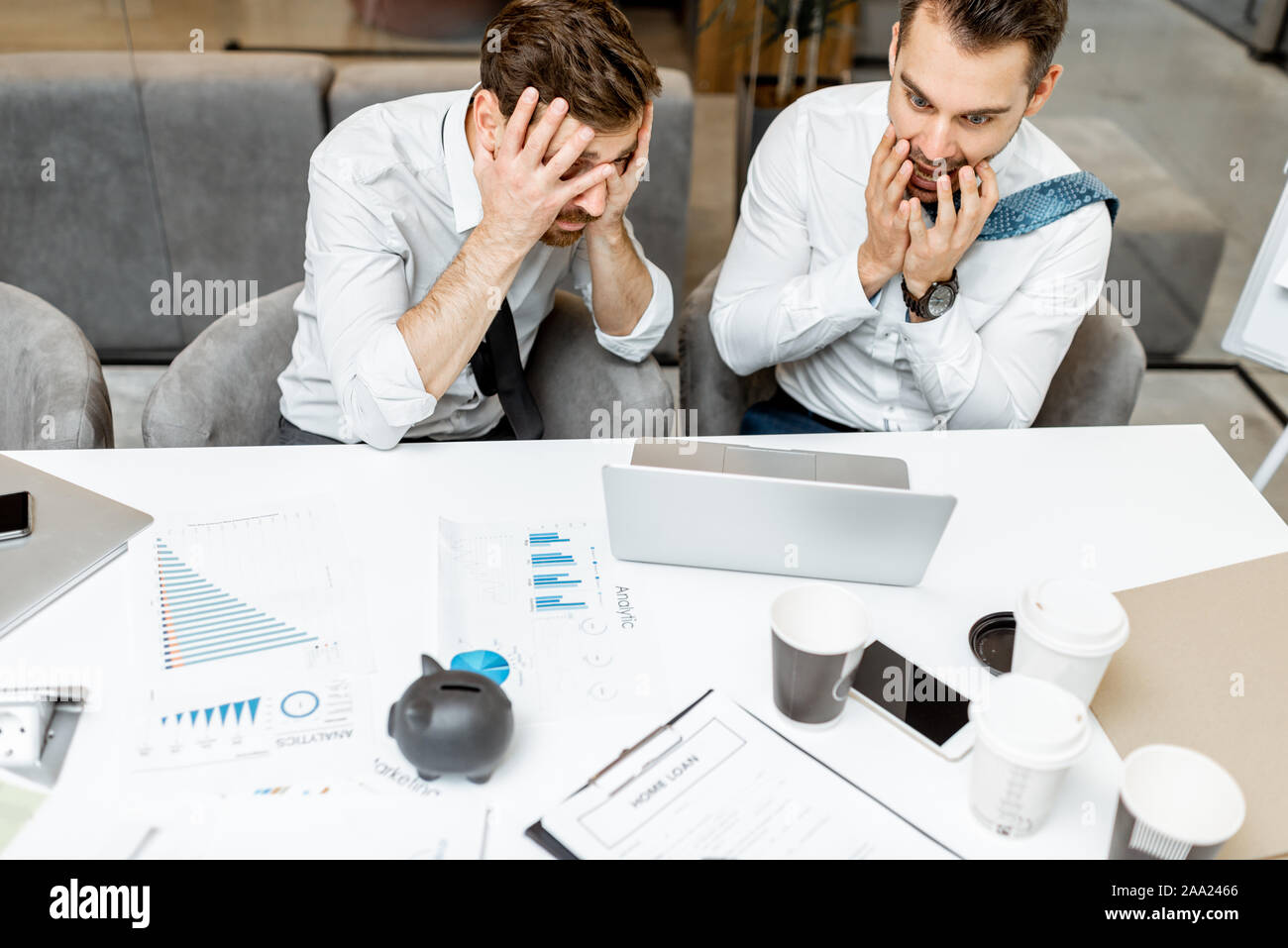 Two exhausted and tired employees hard working with laptop in the ...