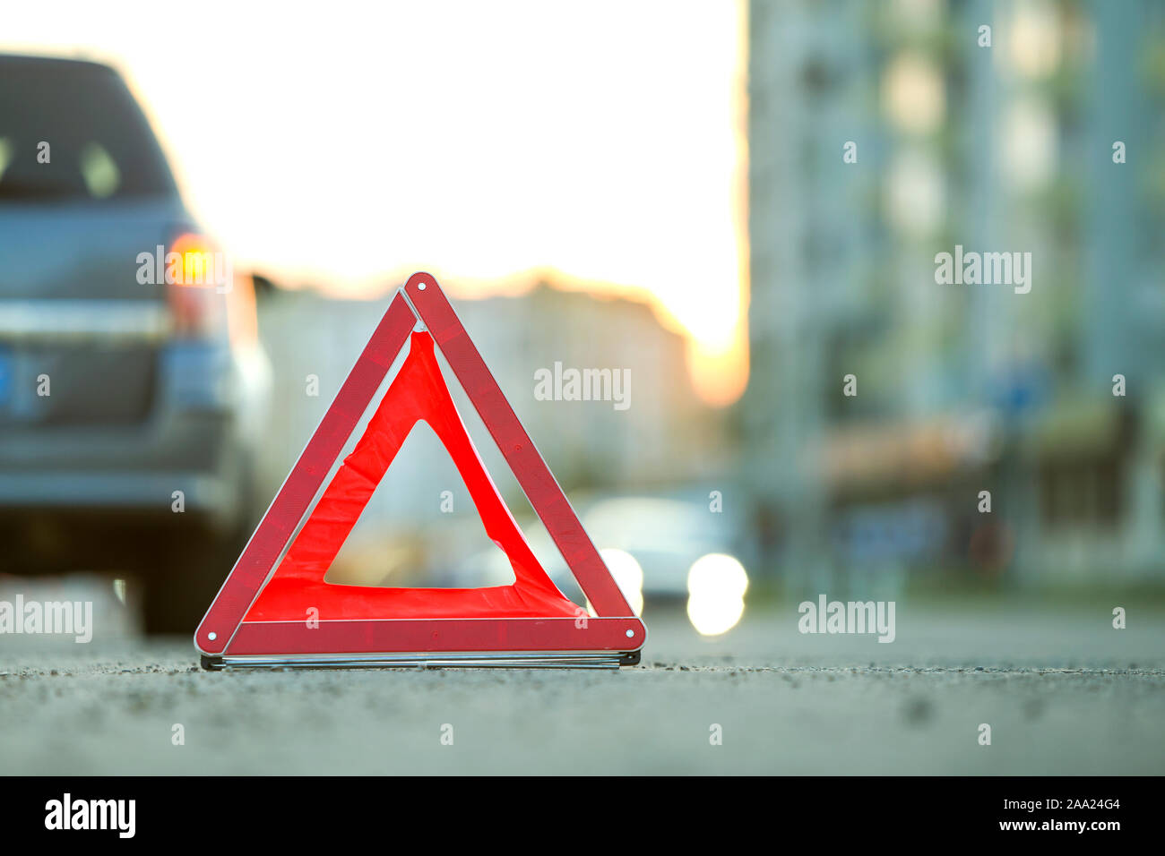 Red emergency triangle stop sign and broken car on a city street Stock ...