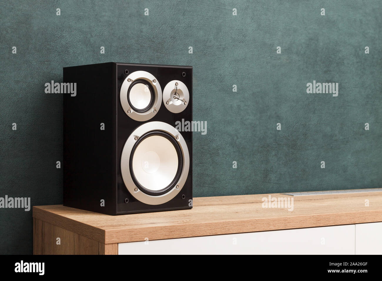 One modern black audio speaker system in interior on wooden desk near ...