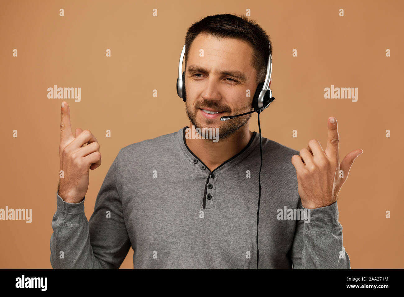 handsome emotional call center worker man isolated on beige background ...
