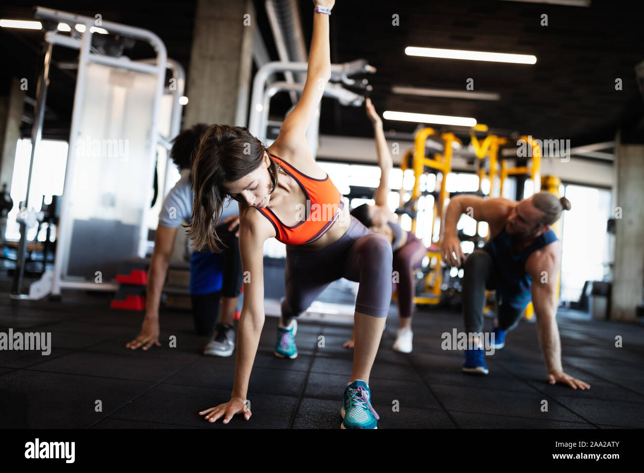 Healthy young people doing exercises at fitness studio Stock Photo - Alamy