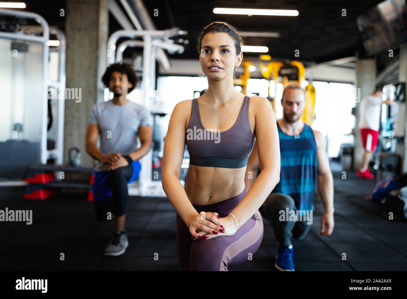 Healthy young people doing exercises at fitness studio Stock Photo - Alamy