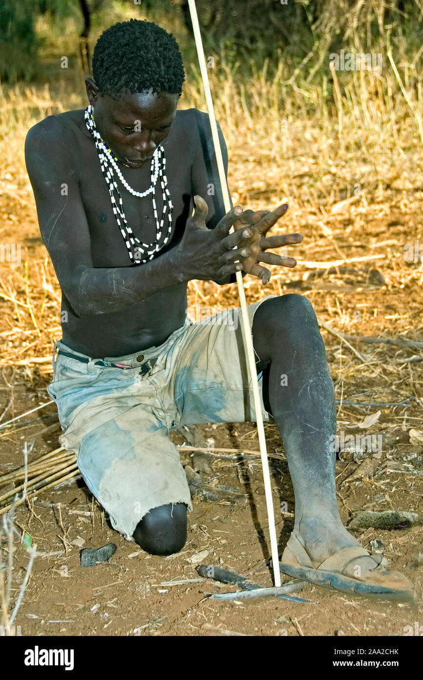 Hadzabe bushman making up fire with sticks. Lake Eyasi, northern ...