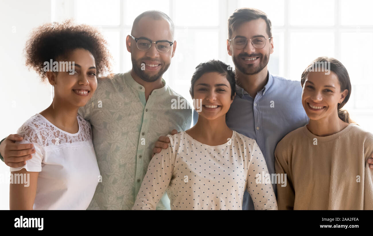 Head shot portrait of happy diverse friends, embracing near window ...