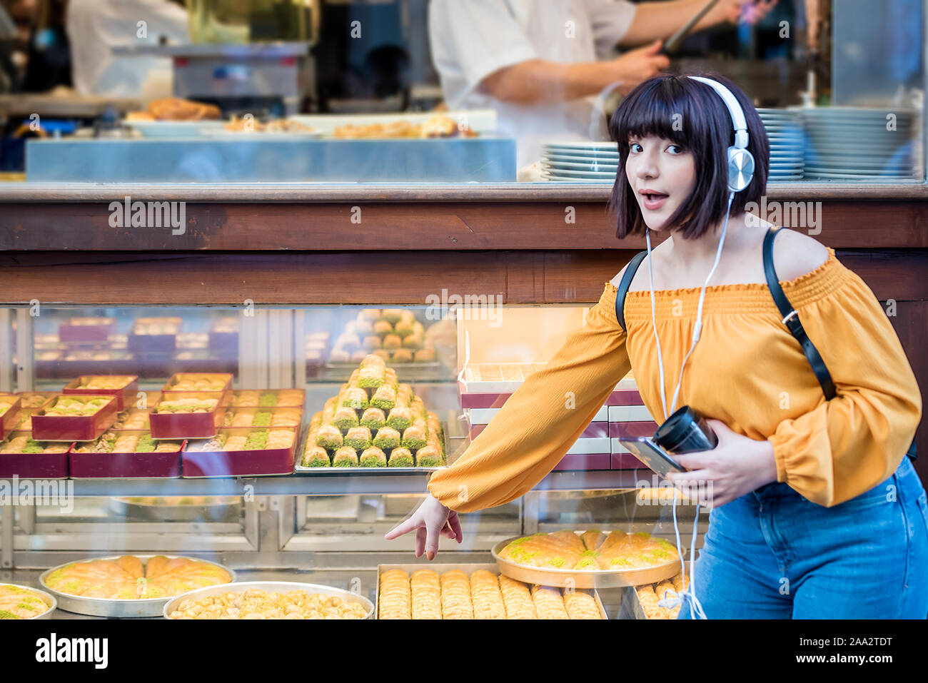 Beautiful young girl in fashionable clothes shows traditional Turkish ...