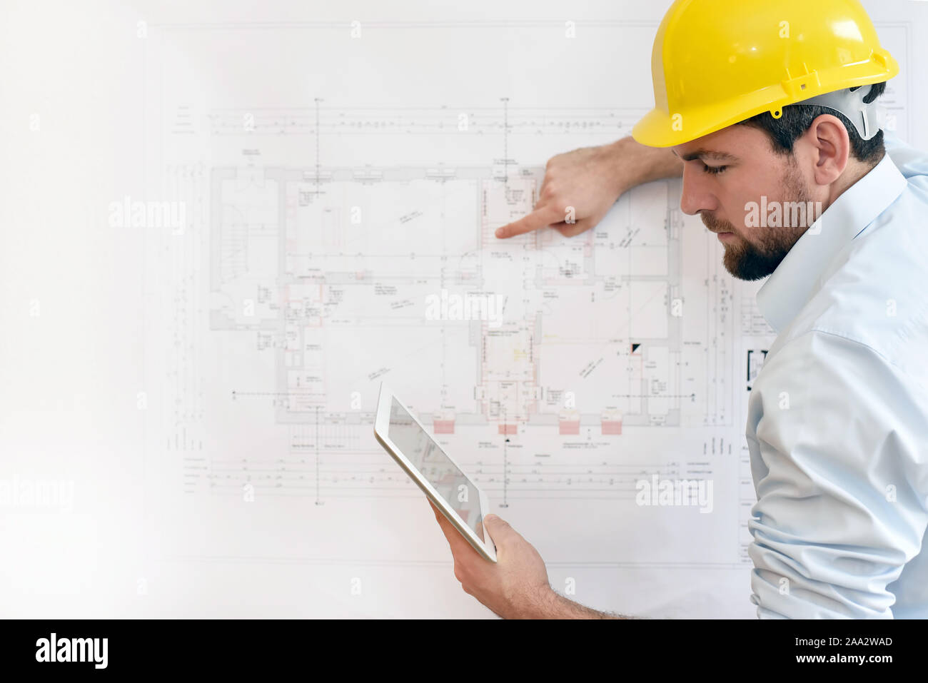 Architect / engineer at his desk planning the construction of a house ...