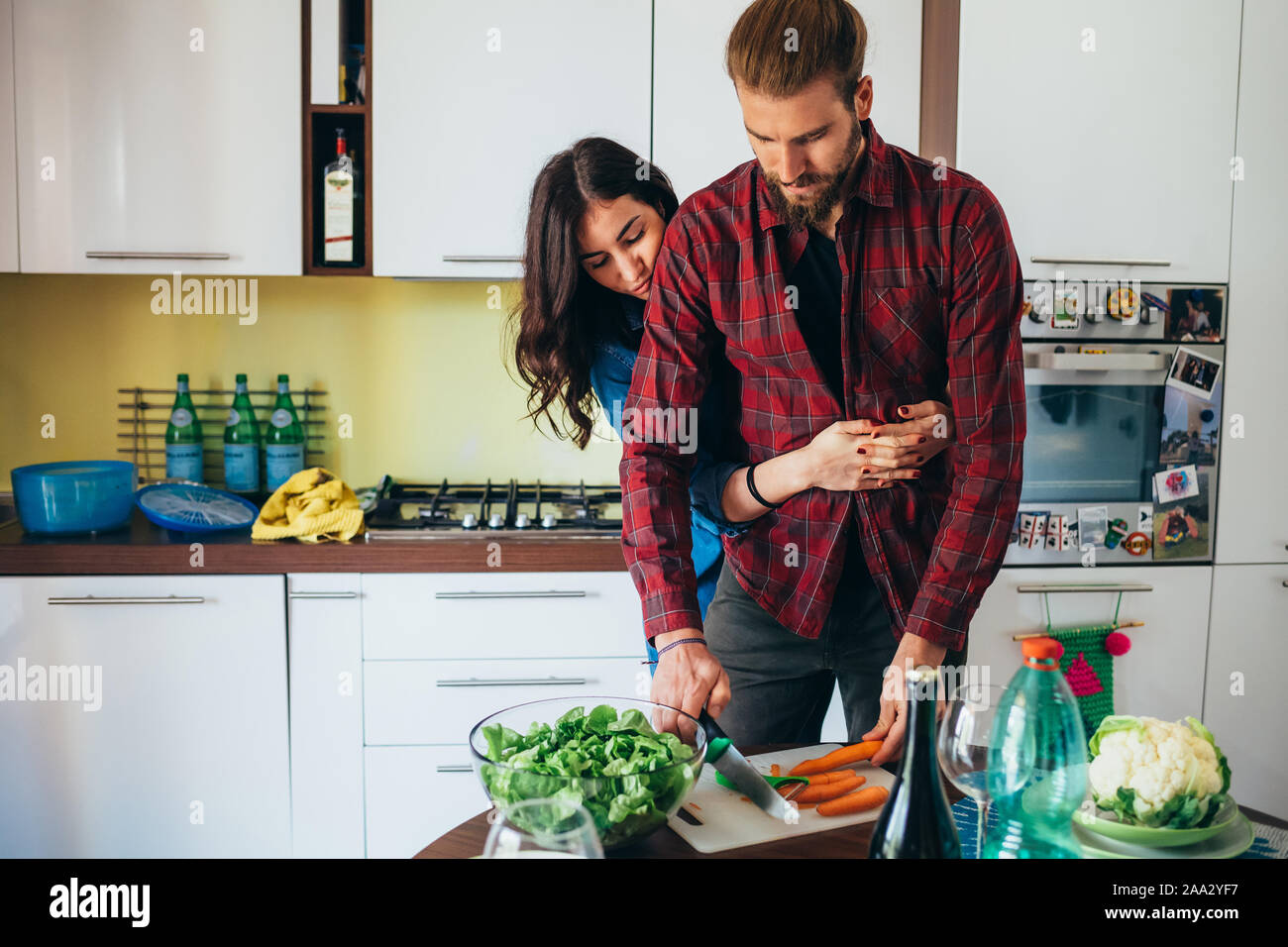 Affectionate young couple cooking food in kitchen at home - romantic ...