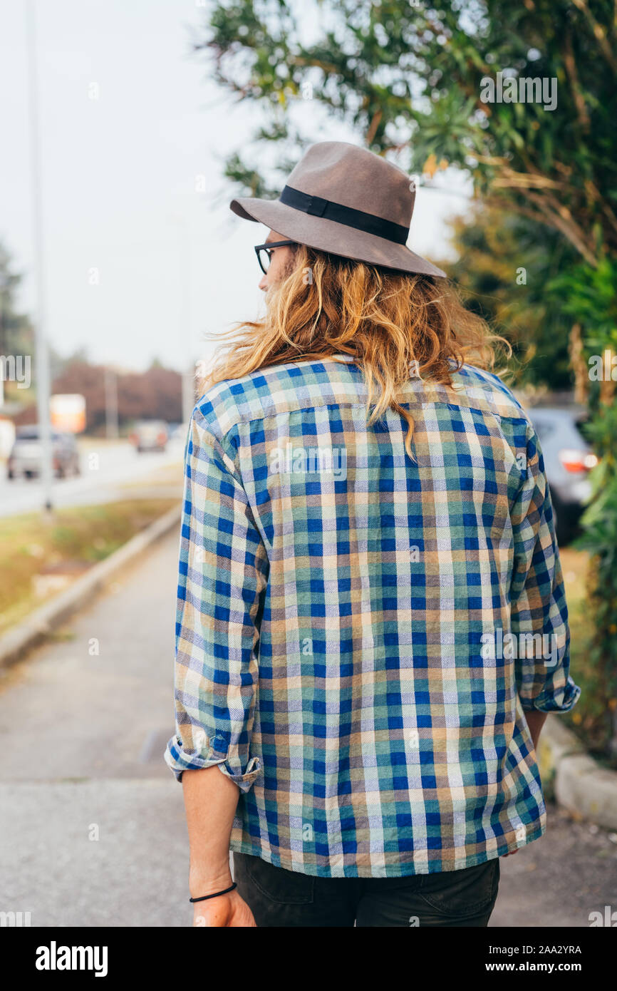 Back view young long hai r man walking away - leaving, getting away ...