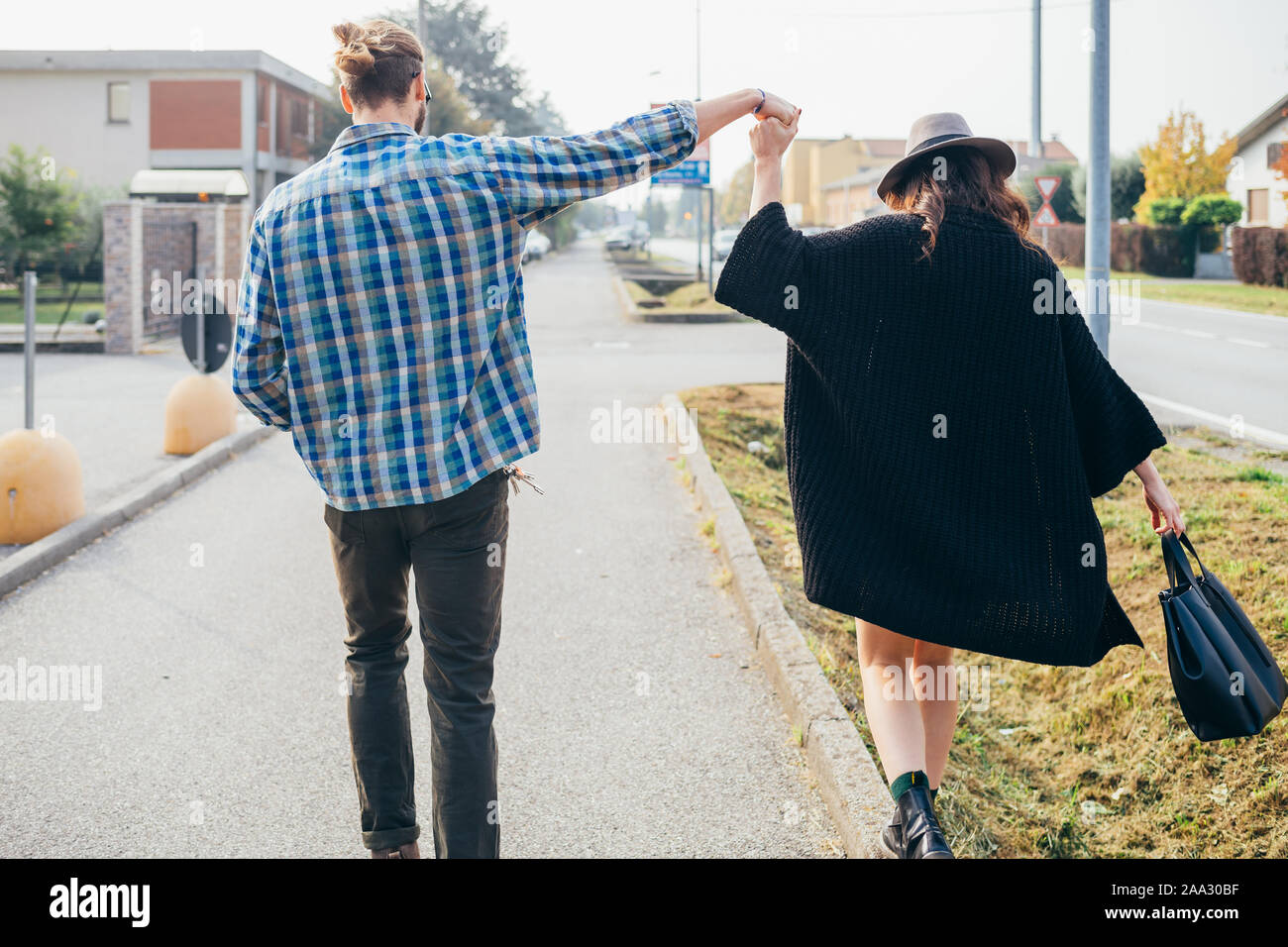 back view affectionate beautiful couple walking outdoor holding hands ...