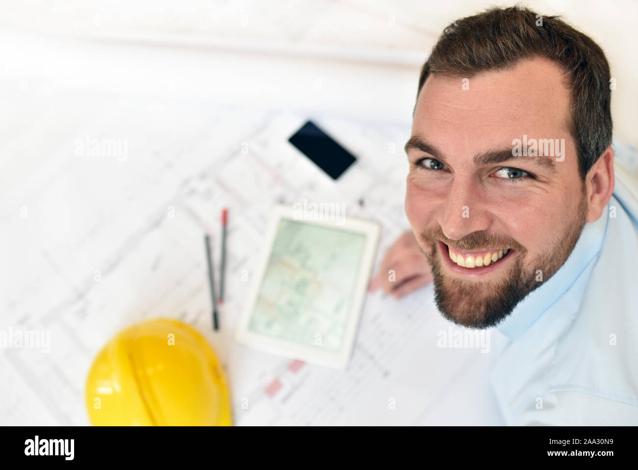 Architect / engineer at his desk planning the construction of a house ...
