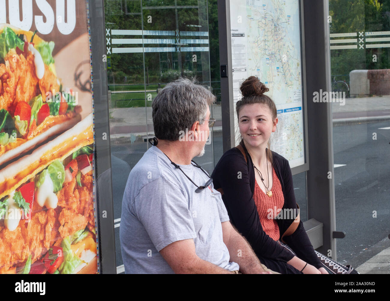 Conversation between two people at bus stop in Amsterdam Stock Photo ...